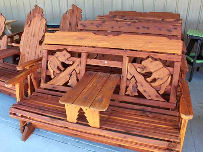 A glider bench carved with bear designs, perfect for sitting outside and pretending you're more outdoorsy than you actually are.