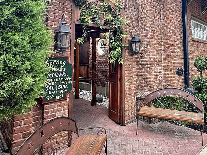 That charming brick courtyard entrance promises comfort food and Southern hospitality waiting just beyond those welcoming wooden doors.