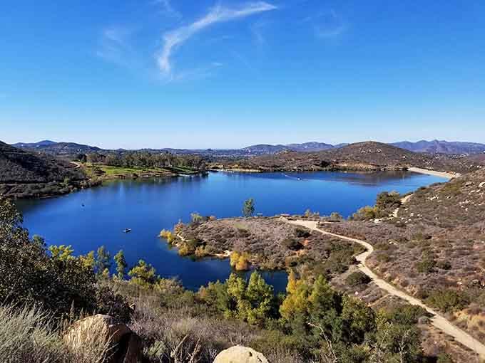 This hidden reservoir gleams like a jewel set in sun-baked hills, inviting wanderers to explore its shores.