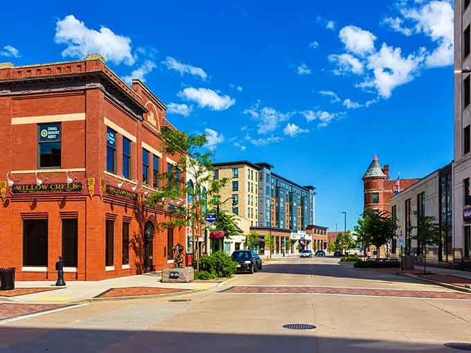 Downtown Eau Claire glows under cotton-candy clouds, where brick buildings meet modern energy in perfect harmony.