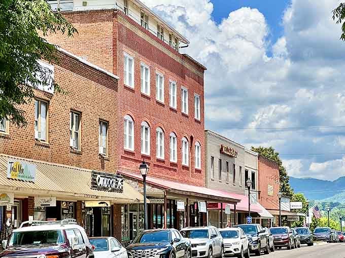 Classic brick storefronts line up like old friends under dramatic mountain clouds that remind you why postcards exist.