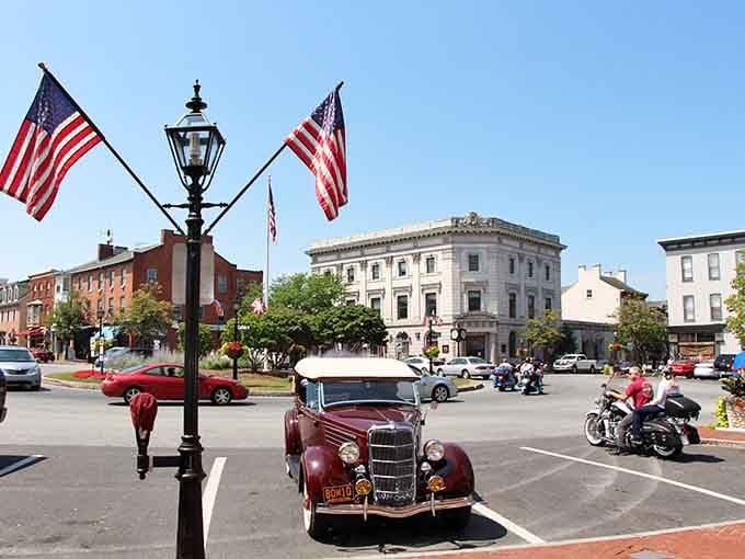 Old Glory waves over Lincoln Square while a vintage roadster parks like it owns the place.