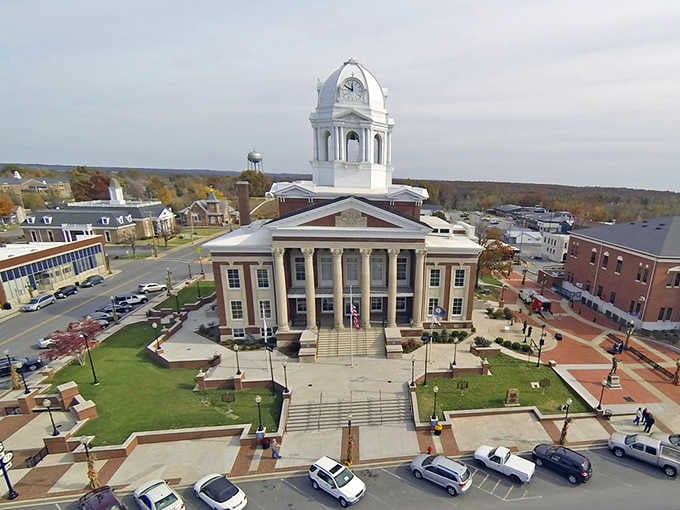 That gleaming white cupola reaches skyward like a beacon, anchoring this perfectly preserved town square with timeless grace.
