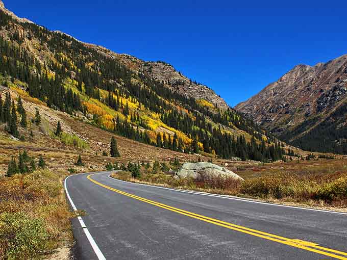 Golden aspens paint the mountainsides while this winding road invites you into autumn's most spectacular gallery.
