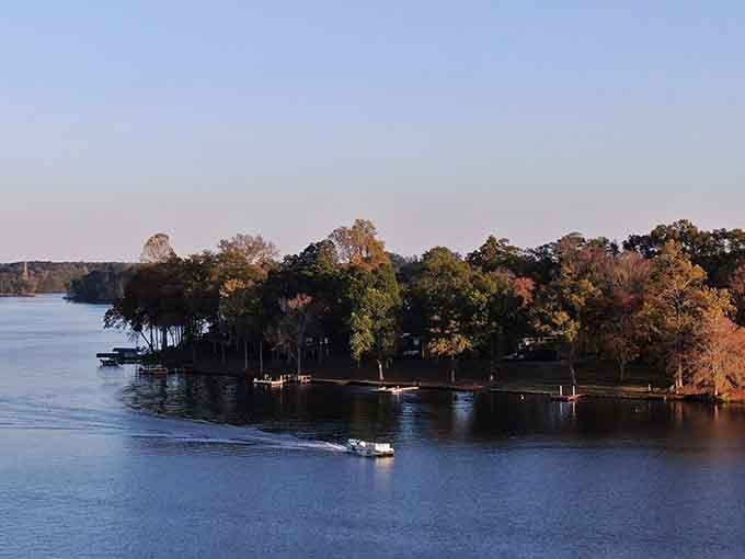 Golden hour transforms this tree-lined peninsula into a watercolor painting, with boats dotting the calm surface below.