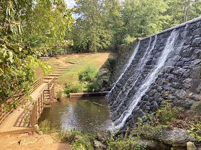 That wooden boardwalk leads you right to this stunning dam spillway where water cascades like nature's own fountain show.