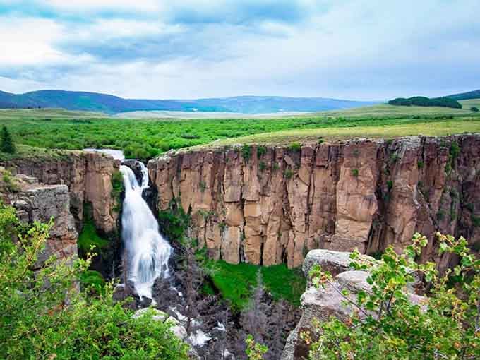 Water plunges through towering canyon walls like nature's own grand entrance, dramatic and utterly unforgettable.