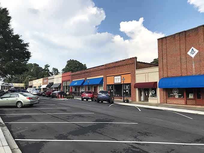 Classic brick storefronts with colorful awnings remind you that small-town shopping beats scrolling through your phone any day.