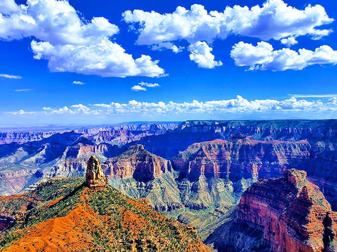 Those puffy clouds floating over layered canyon walls create a view that makes postcards look boring by comparison.