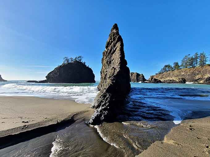 That dramatic sea stack rising from the sand looks like nature's exclamation point on this hidden paradise.