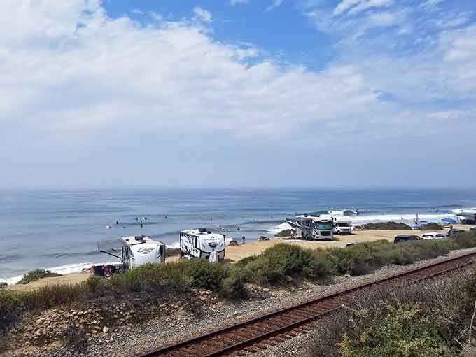 Surfers catching morning waves while RVs line the shore&mdash;this is beachfront camping done absolutely right.