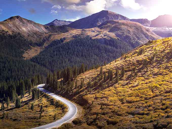 That ribbon of pavement snaking through golden hillsides proves the journey really is better than the destination.