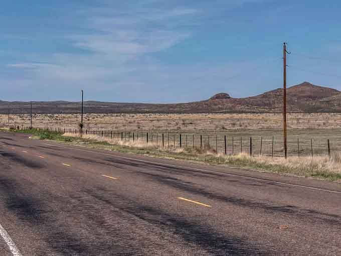 Wide open spaces meet endless blue sky where telephone poles stand like lonely sentinels watching over the desert.