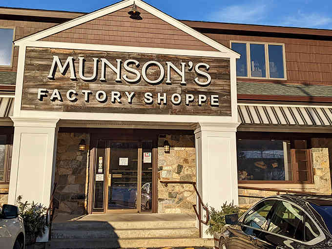 Sunshine bathes this charming storefront where handcrafted chocolates await—notice how the stone and wood blend perfectly together.