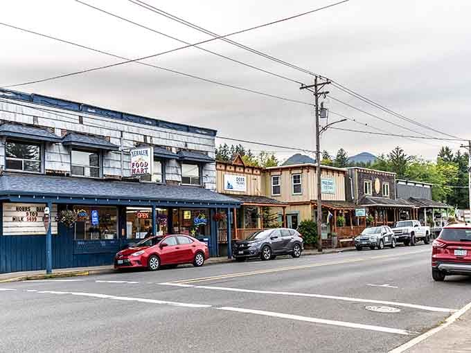 That blue-trimmed building houses local treasures, while the mountains stand guard like patient sentinels over this charming street.