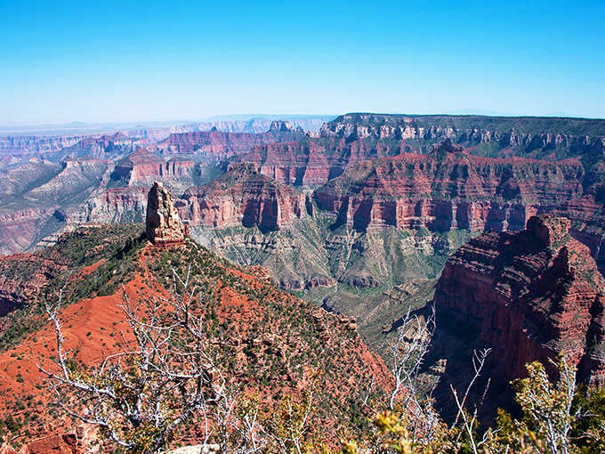 The North Rim reveals striped rock formations in rust and sage that stretch endlessly toward distant mesas.