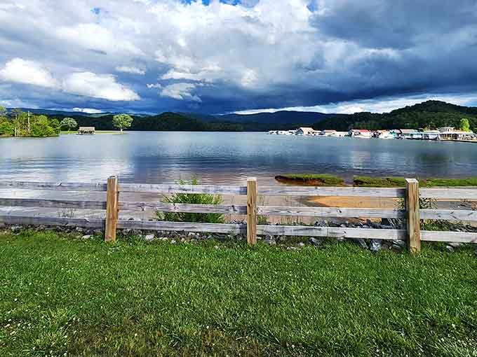 That split-rail fence frames the lake like a postcard, with storm clouds adding free drama to the view.
