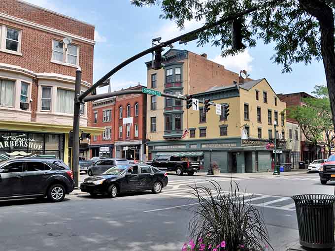 Tree-lined corners and colorful storefronts create that perfect neighborhood feel where community actually means something special.