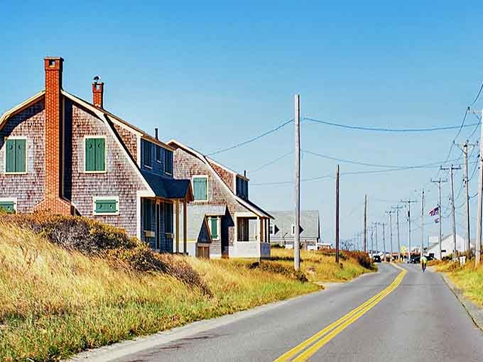 The open road stretches toward weathered Cape Cod homes where salt air and golden dunes create pure magic.