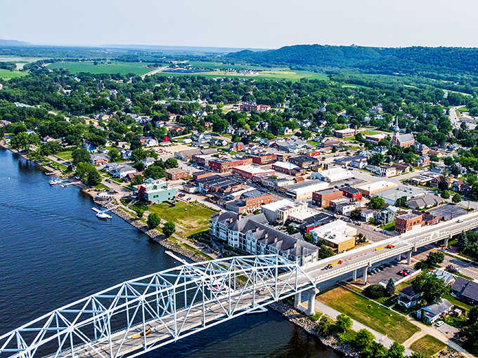 From above, the Mississippi River cradles this riverside gem like nature's own protective embrace, bridge and all.