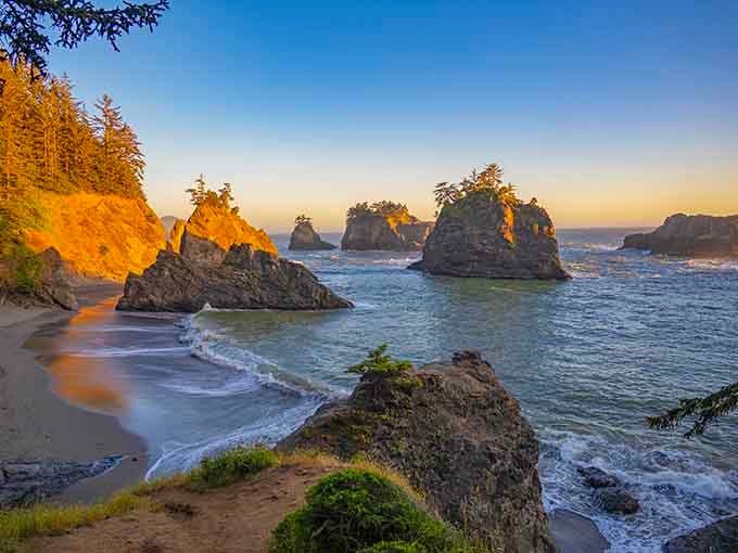 Golden hour transforms the beach into something magical, painting rocks and waves in sunset's warm embrace.