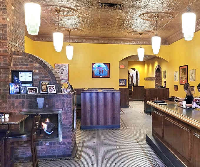 Yellow walls and tin ceilings create warmth that no modern restaurant designer could ever replicate with a mood board.