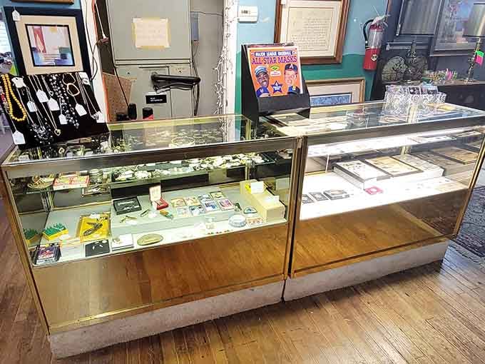 Vintage jewelry gleaming behind glass like precious memories your grandmother might have worn to Sunday dinner.