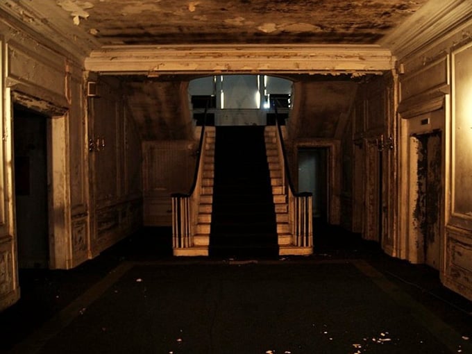 That staircase once welcomed guests; now it welcomes only shadows and memories of better days.