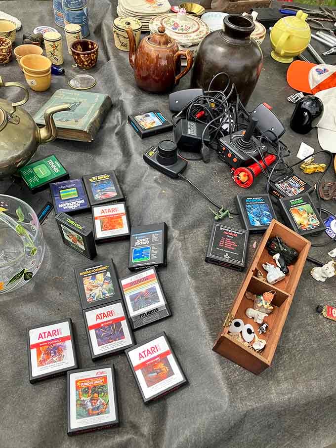 Atari cartridges and vintage teapots share table space, because nothing says "eclectic" quite like gaming nostalgia meeting afternoon tea traditions.