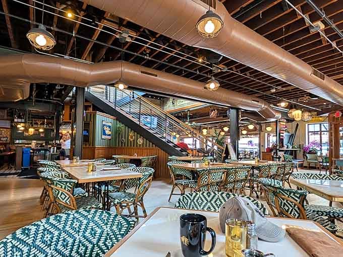 Industrial meets European caf&eacute; chic, and somehow those patterned chairs make perfect sense with the exposed ductwork overhead.