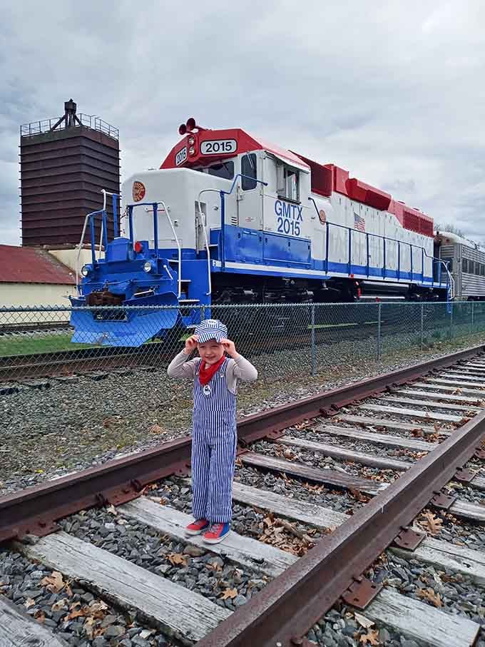 Future railroad engineer in training, complete with conductor outfit and an expression of pure childhood wonder.