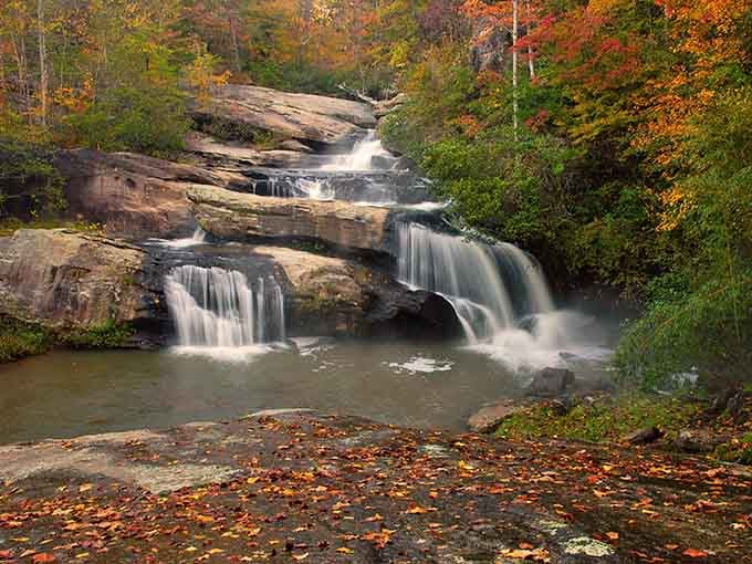 Autumn leaves frame the falls like nature hired a professional decorator who actually knew what they were doing.