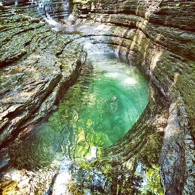 The Devil's Bathtub sits nestled in layered limestone like nature's own perfectly carved spa retreat awaiting your arrival.
