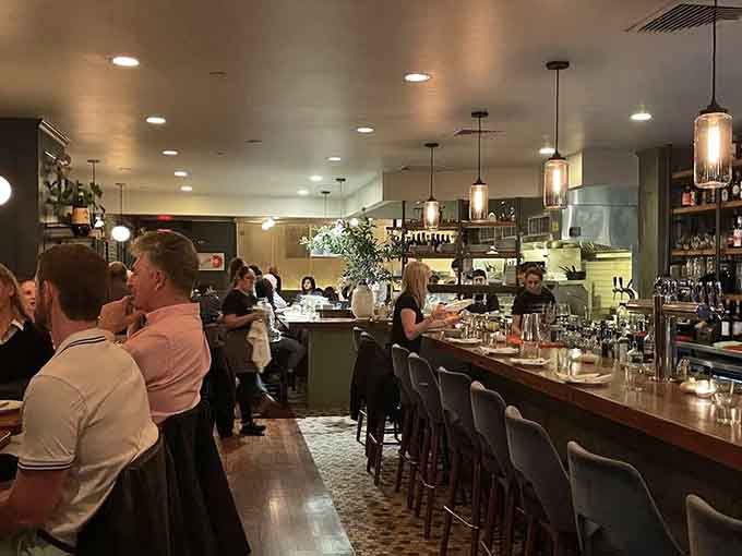 Inside, the open kitchen and bustling bar create an energy that says "something special happens here nightly."