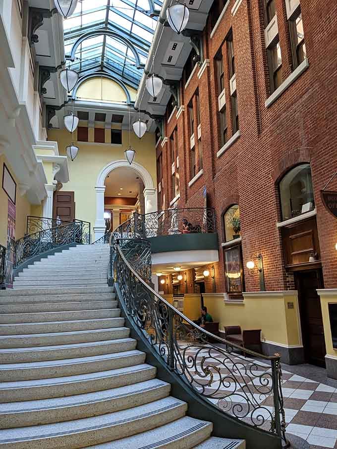 That ornate ironwork staircase curves upward like something from a Victorian dream, beckoning you to explore higher.