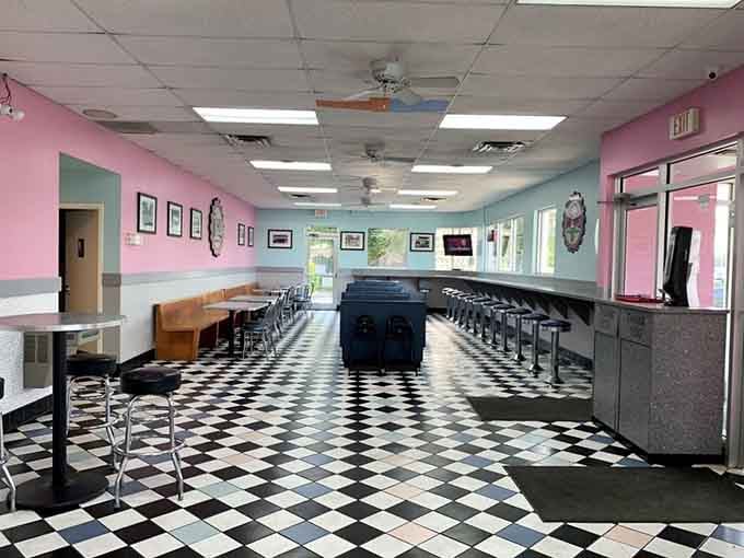 Pink and blue walls meet checkered floors in a time capsule so perfect you'll check your phone for the date.