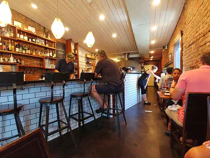 Exposed brick, pendant lights, and bar seating where you can watch pizza artistry unfold before your eyes.