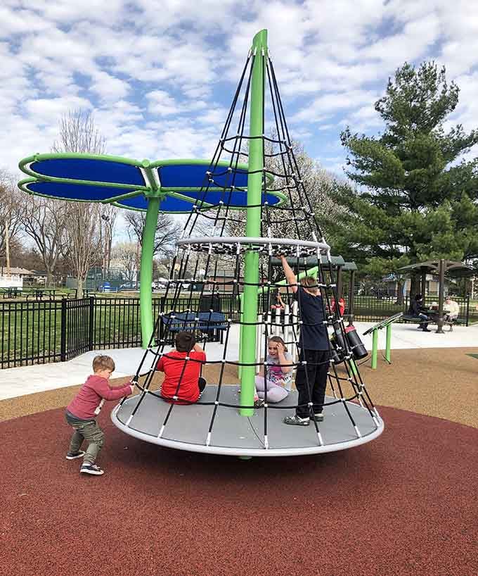 Kids climbing together on the conical rope structure, proving that the best playgrounds bring everyone into the action.