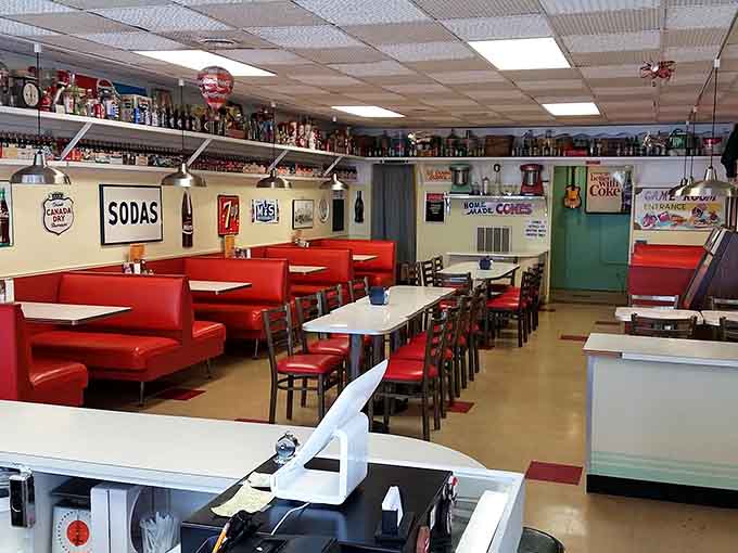 Red vinyl booths and vintage soda signs create a time machine that runs on nostalgia and sugar.