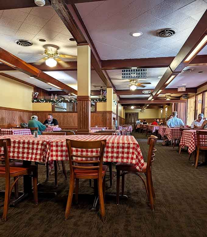 Red checkered tablecloths and warm wood paneling create the kind of cozy atmosphere your grandmother would approve of.