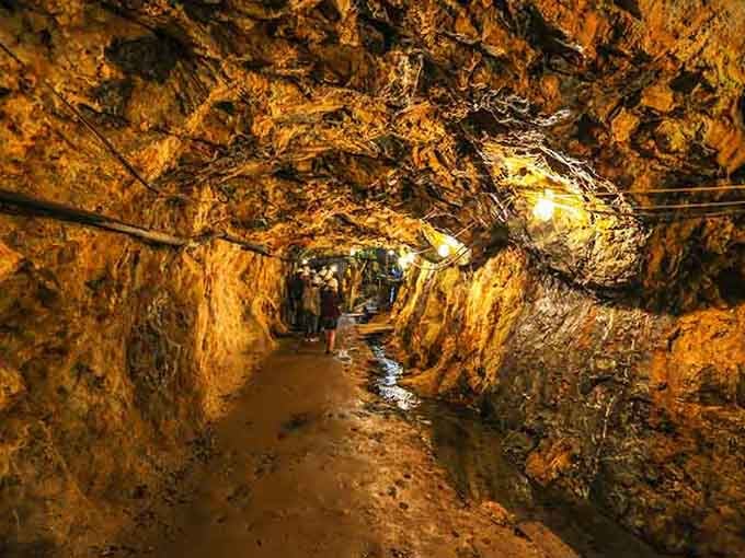 The golden-hued tunnel walls tell stories of miners who carved these passages one swing at a time.