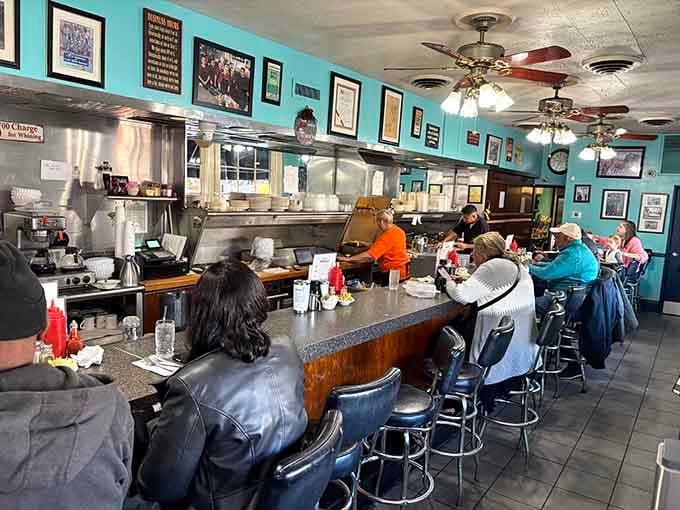 Counter seating where the real magic happens, turquoise walls cheerful enough to make morning people tolerable.