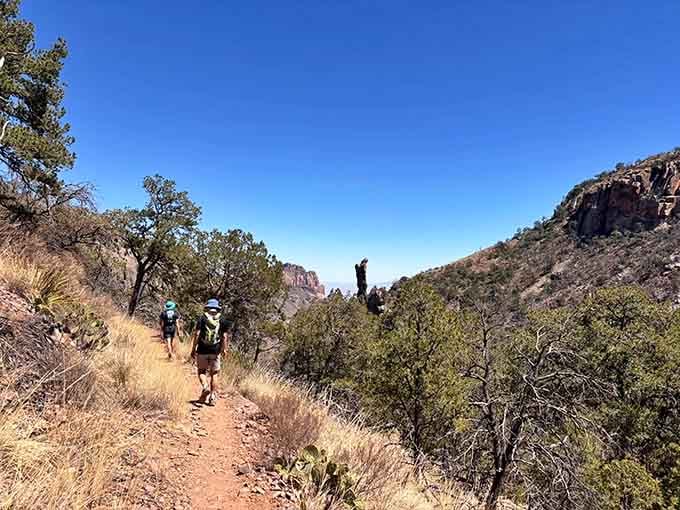 Following fellow adventurers up the path, where that towering rock formation looks like it's photobombing the landscape.