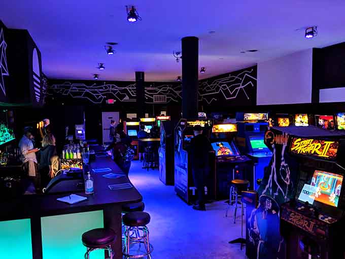 Purple lighting bathes rows of classic arcade cabinets in that nostalgic glow you remember from childhood pizza parlors.