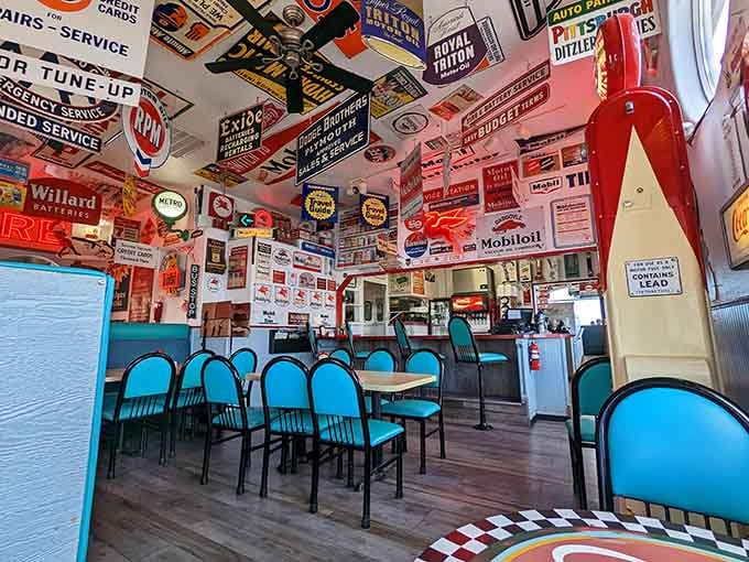 Every square inch tells a story in this automotive memorabilia paradise where turquoise chairs meet retro charm.