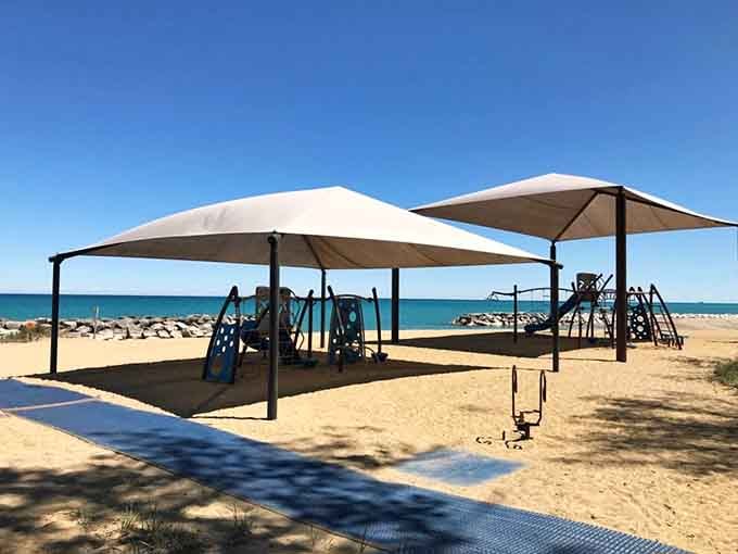 Shaded playground equipment sits ready for action, because even paradise needs a place where kids can burn off energy.