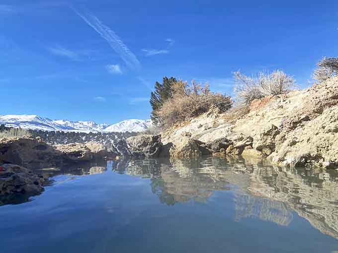 The snow-capped Sierra peaks behind nature's hot tub. Yes, this is real life.