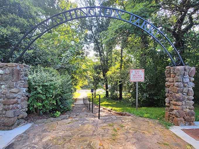 That stone archway welcomes you like a portal to adventure, framed by trees older than your favorite sitcom.