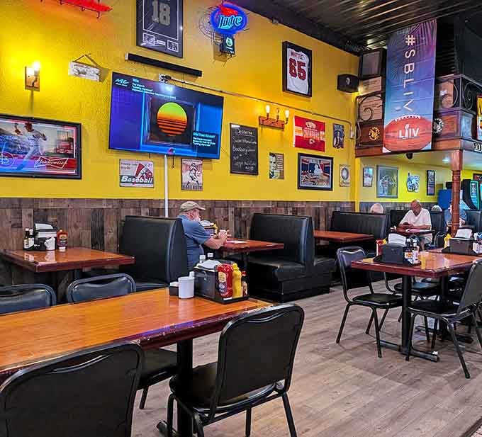 Yellow walls and sports memorabilia create the perfect backdrop for tackling a sandwich that requires strategic planning.