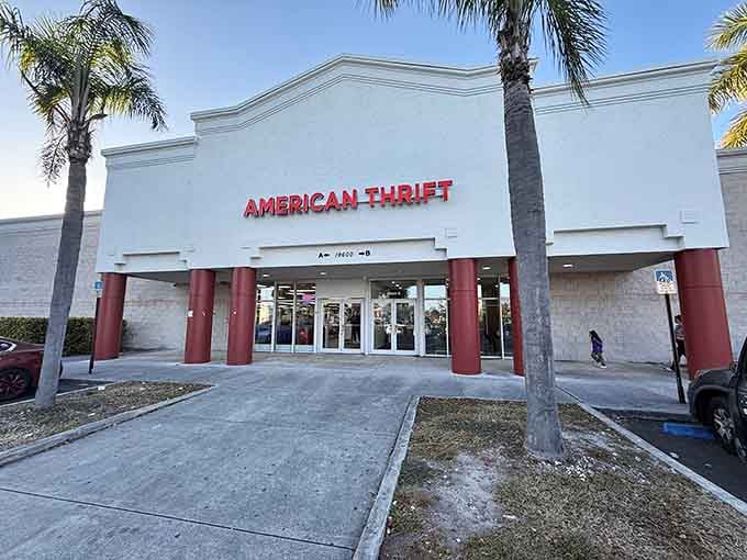 Those red columns frame the entrance like a grand portal to secondhand paradise under swaying palms.